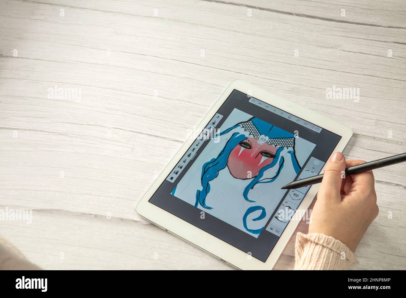 Young creative designer holding stylus pen drawing on screen of digital ...