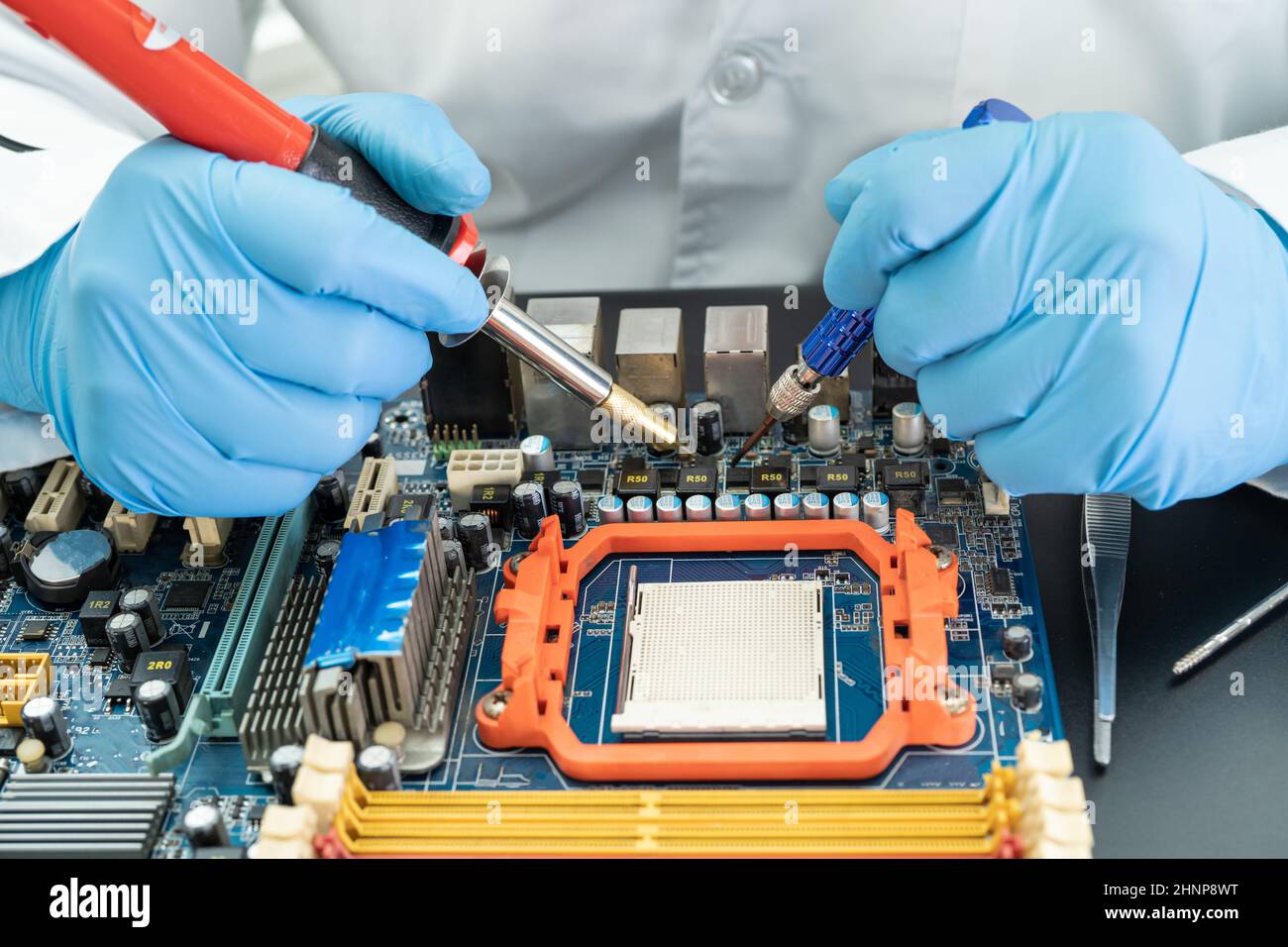technician repairing inside of hard disk by soldering iron. Integrated ...