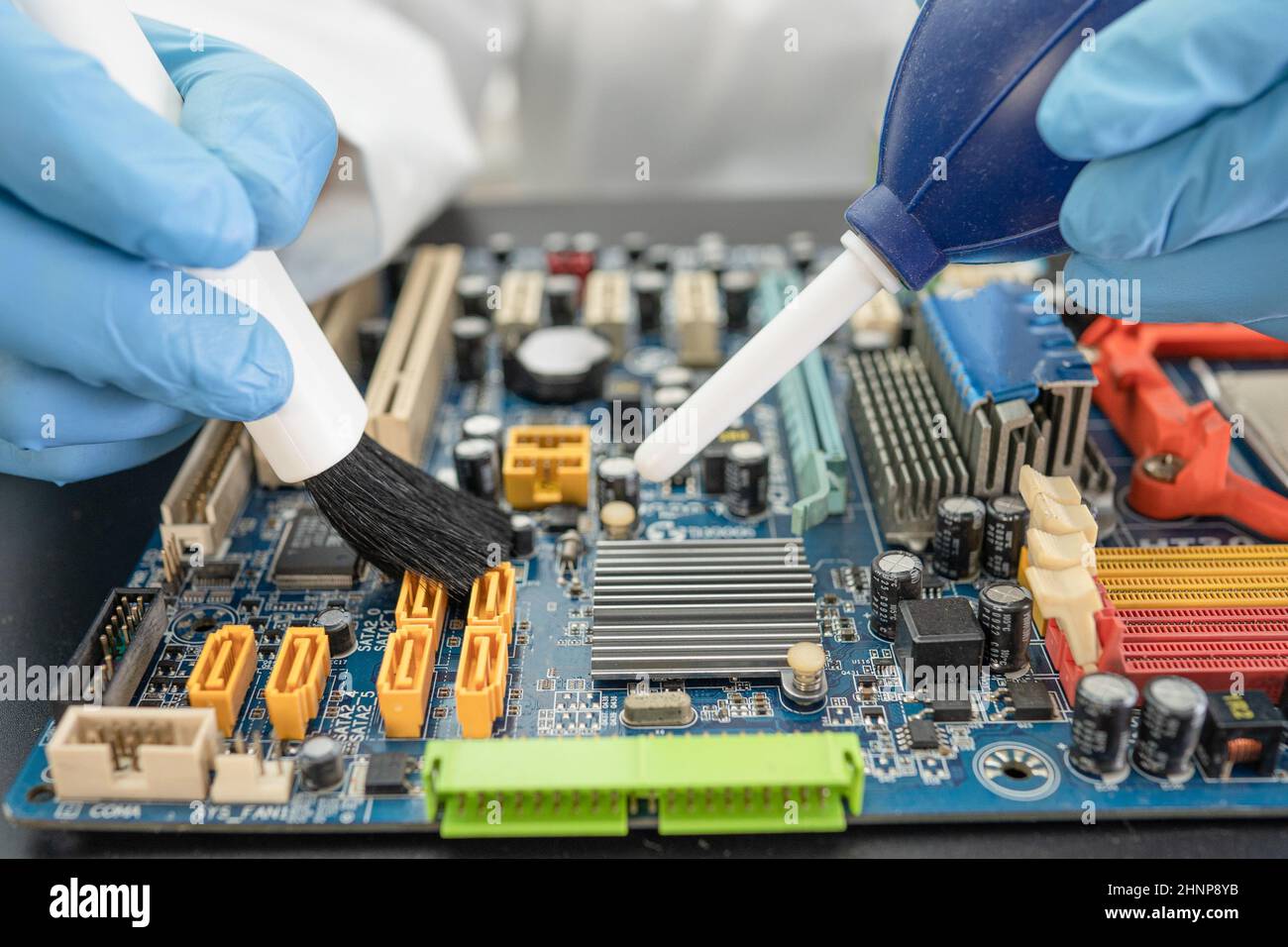 Technician use brush and air blower ball to clean dust in circuit board ...