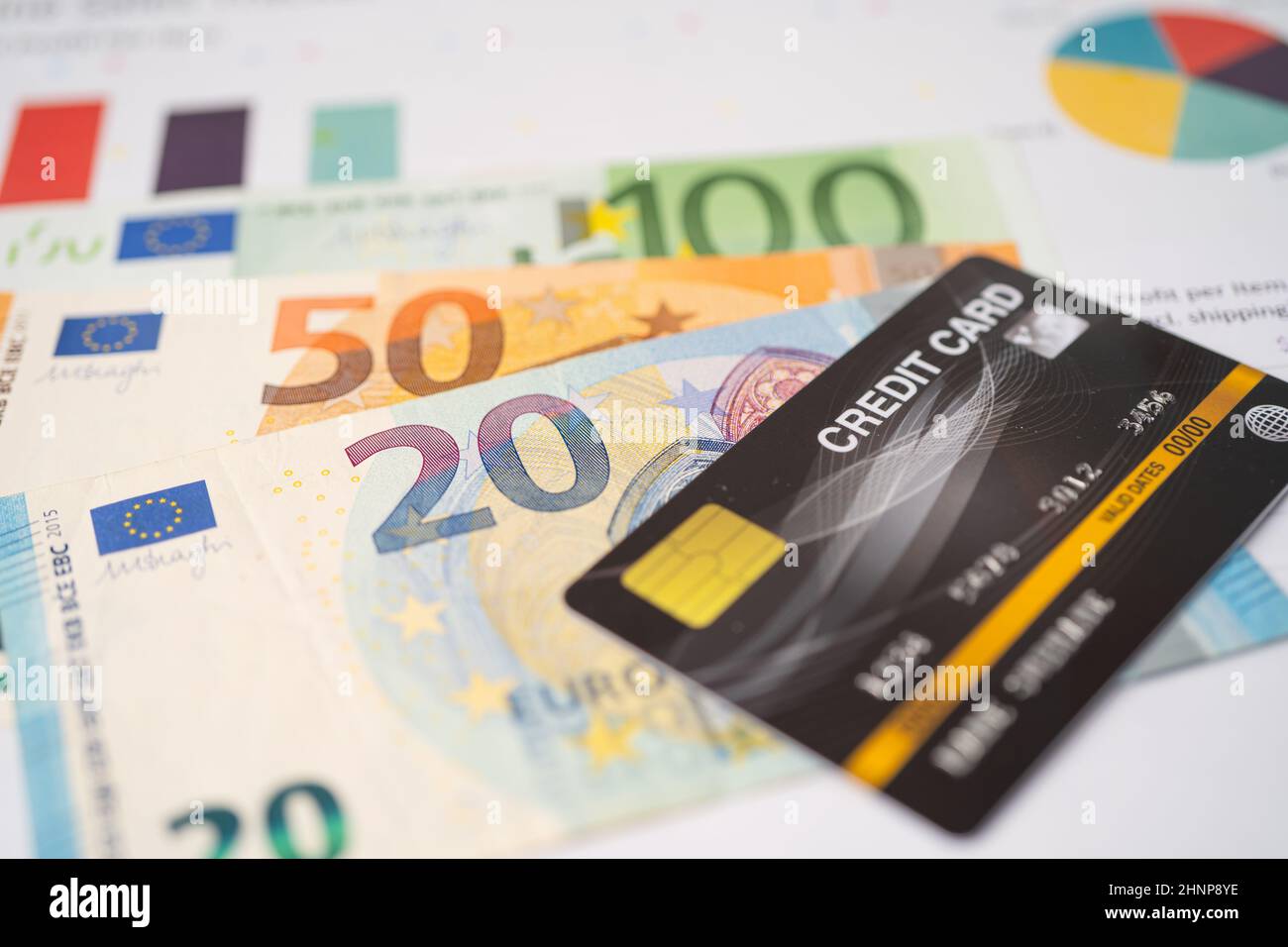 Credit card with Euro banknotes on chart and graph paper. Finance ...