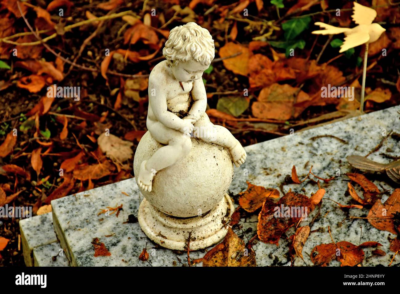 sweet angel figure on a grave in autumn with fallen leaves Stock Photo ...