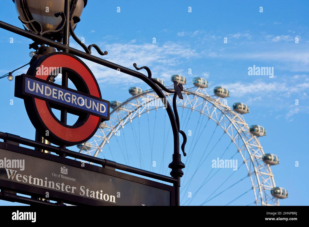 Westminster sign and the London eye blue sky Stock Photo - Alamy