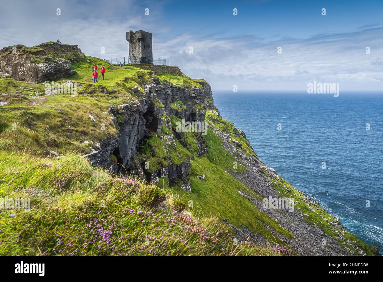 Tourists sightseeing Moher Tower on Hags Head, Cliffs of Moher, Ireland ...