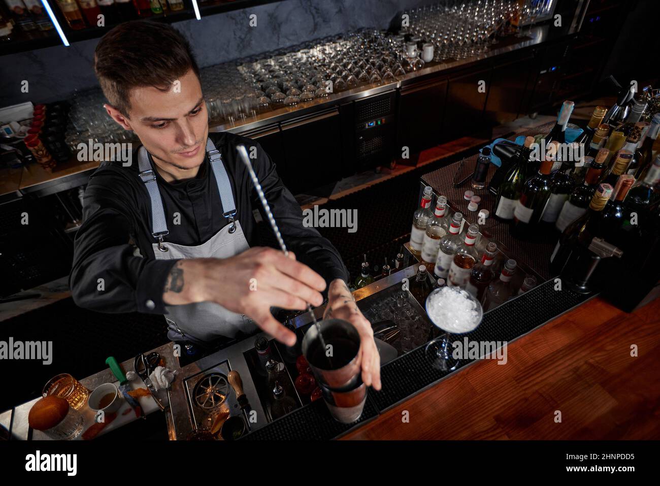 Barman stirring cocktail in shaker with spoon Stock Photo - Alamy