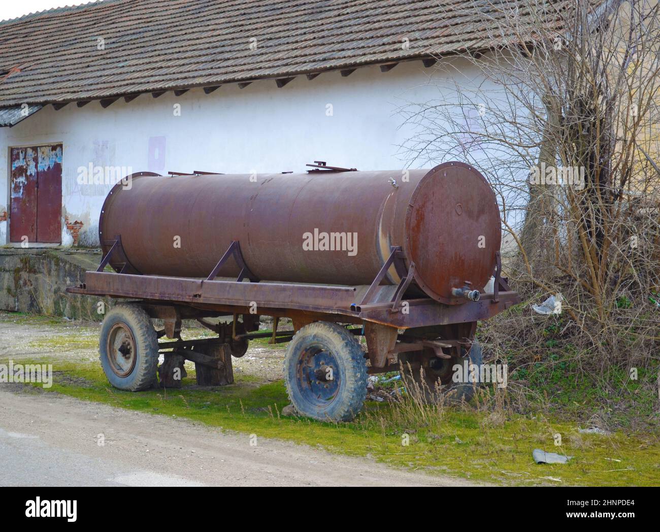 Old rusted water tank parked near the road Stock Photo - Alamy