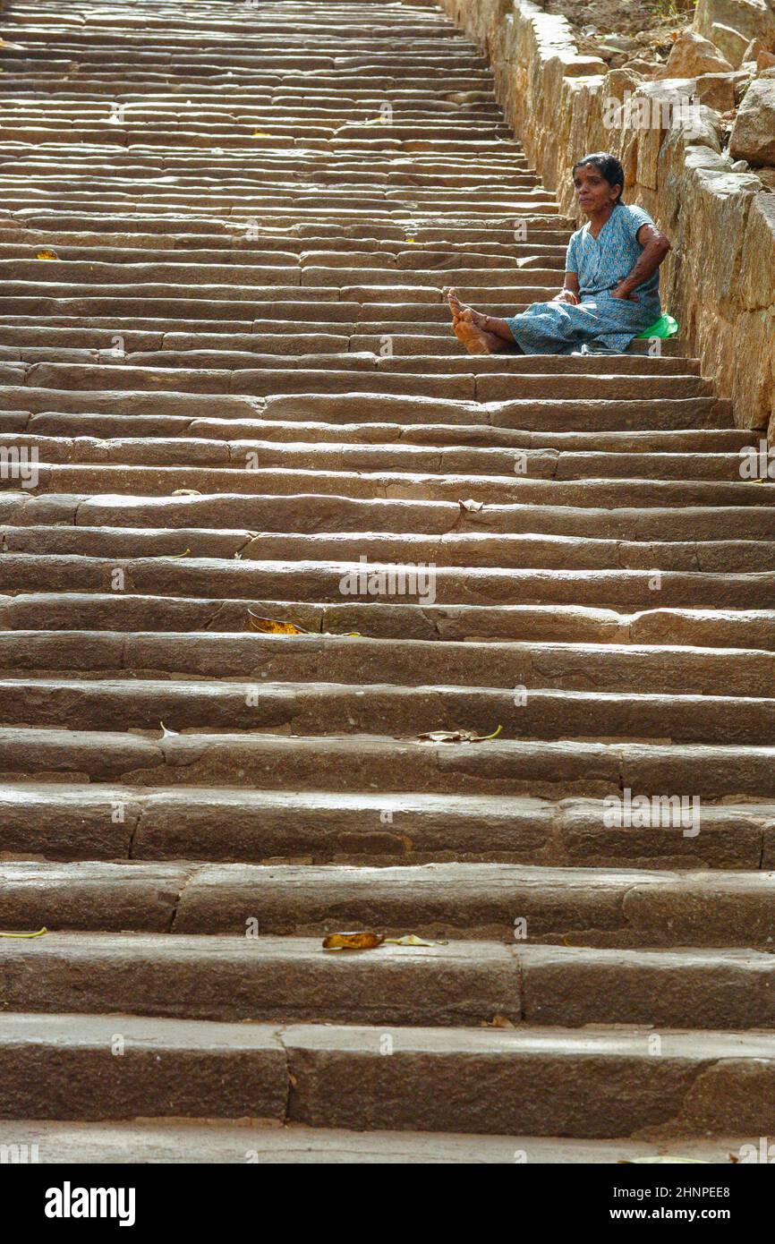 poor woman is begging at the entrance of the temple in Mihintale. Gifts ...