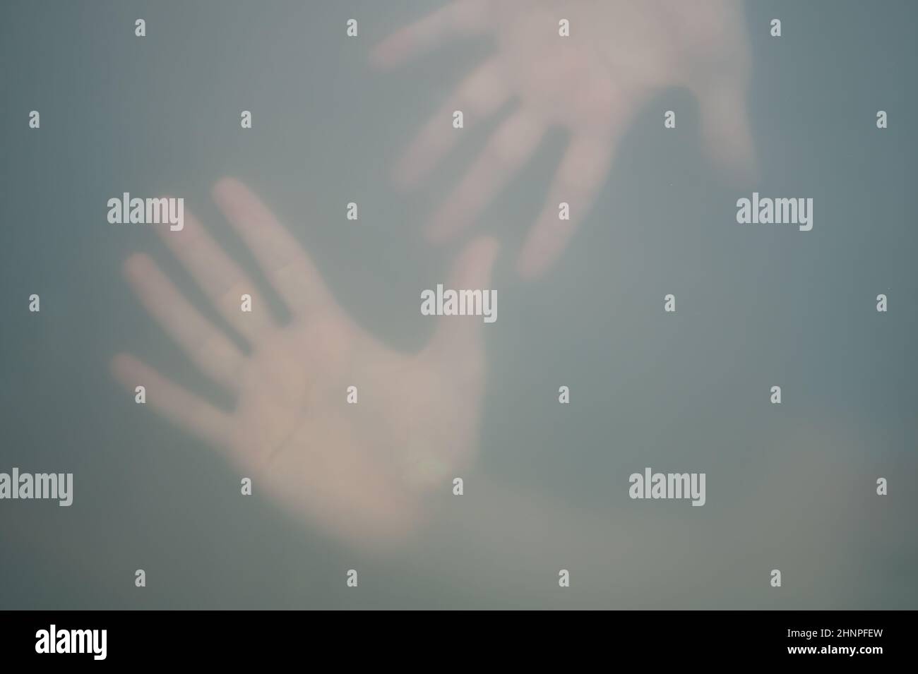 Hands behind the frosted glass. hands silhouette in the mist ...
