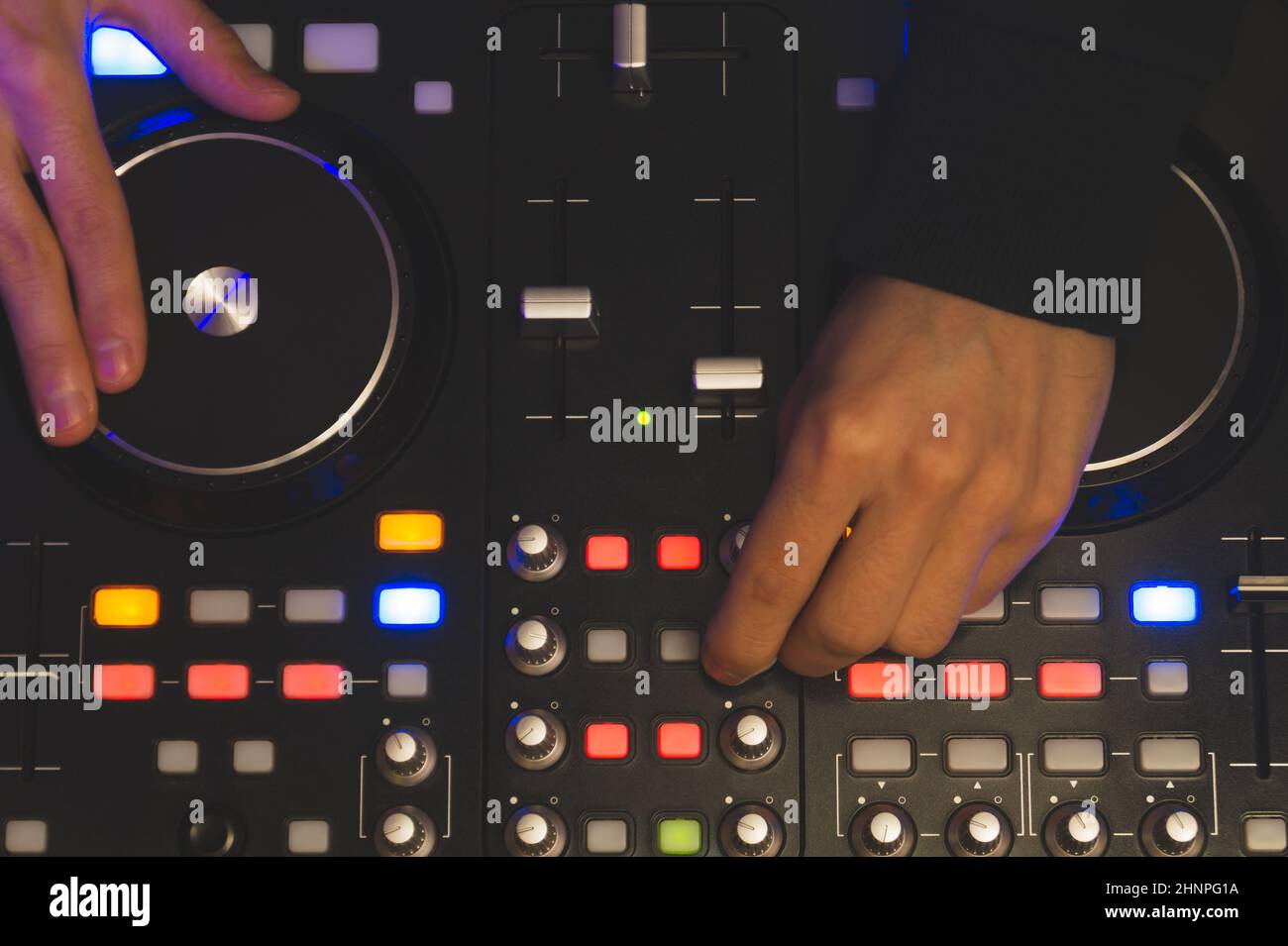 DJ plays music. sound mixer controller with knobs and sliders close up ...