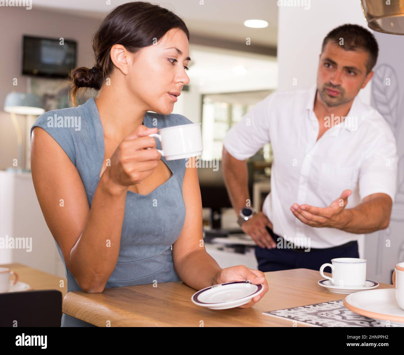 Frustrated girl drinking coffee with angry boyfriend Stock Photo - Alamy