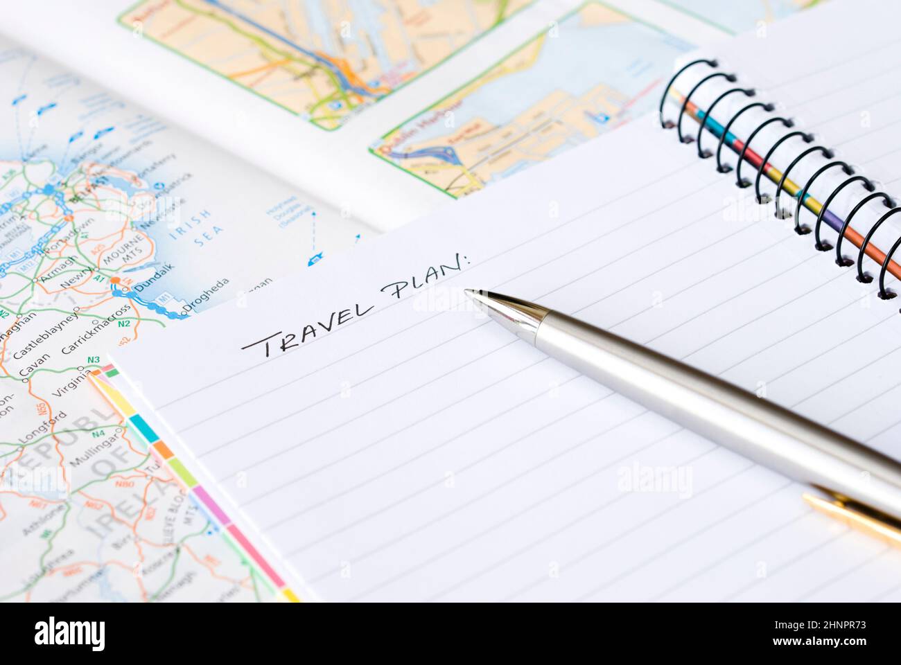 Spiral notebook with silver pen arranged on a map Stock Photo - Alamy