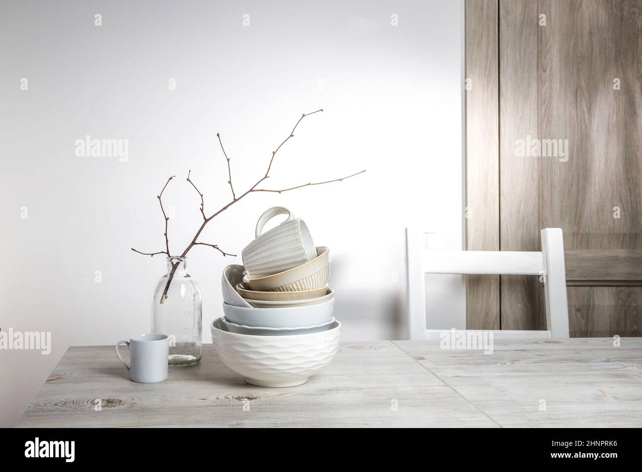 A pyramid of white bowls, plates and cups of different sizes and colors ...