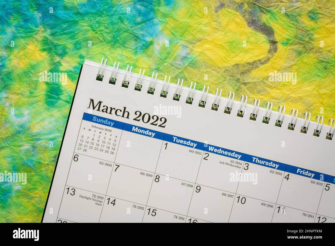 March 2022 - spiral desktop calendar against colorful marbled paper ...