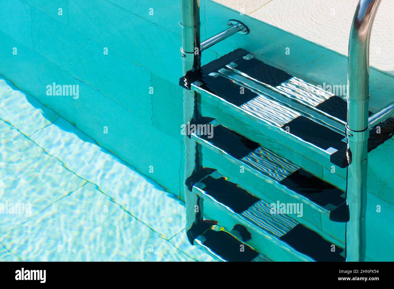 Close-up of ladder in swimming pool water on sunny day, soft focus ...