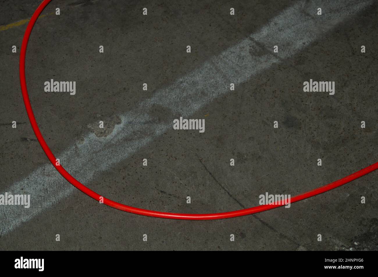 Red electric power cable. red wire lies on the ground. mess on cement ...