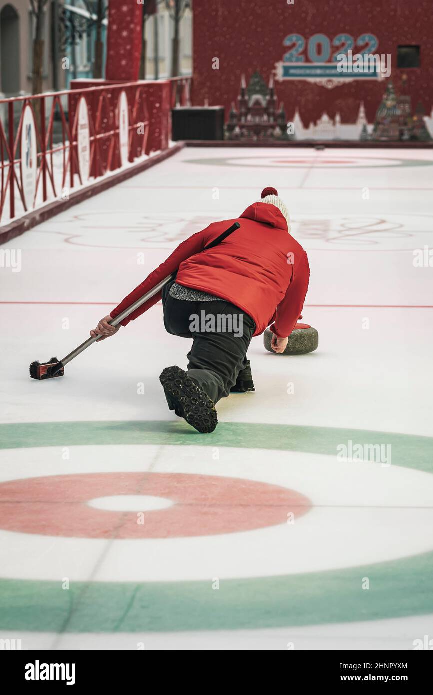 Curling training. Player plays curling on the ice rink, directing stone ...