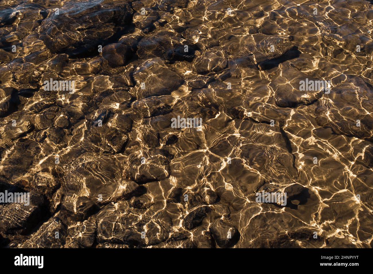 Shiny transparent water. clear water with pebbles and stone on the ...