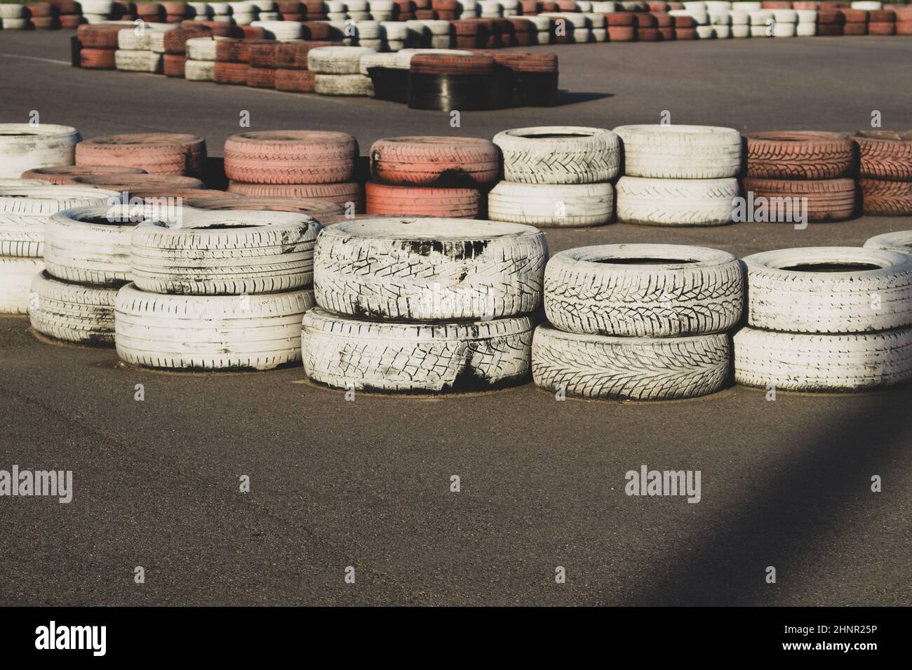 Race track safety barrier. asphalt racing track with red and white tires. colorful tires stack ...