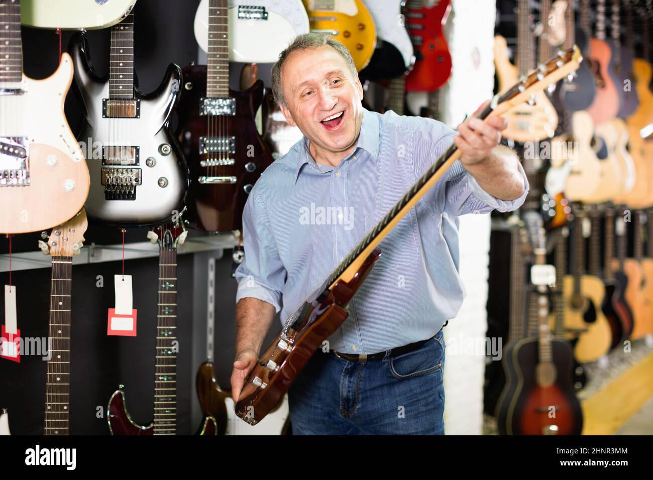 Adult guitarist is playing on electric guitar in music store Stock ...