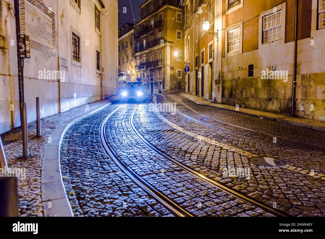 streetcar rails in the old part of Lisbon by night Stock Photo - Alamy