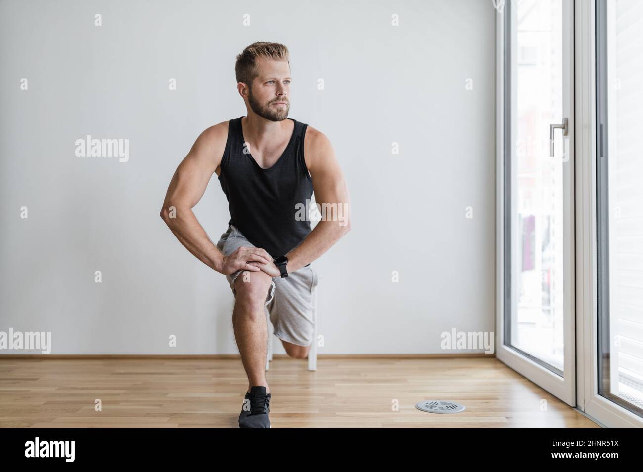 Handsome young man working out at home with a smart watch Stock Photo ...