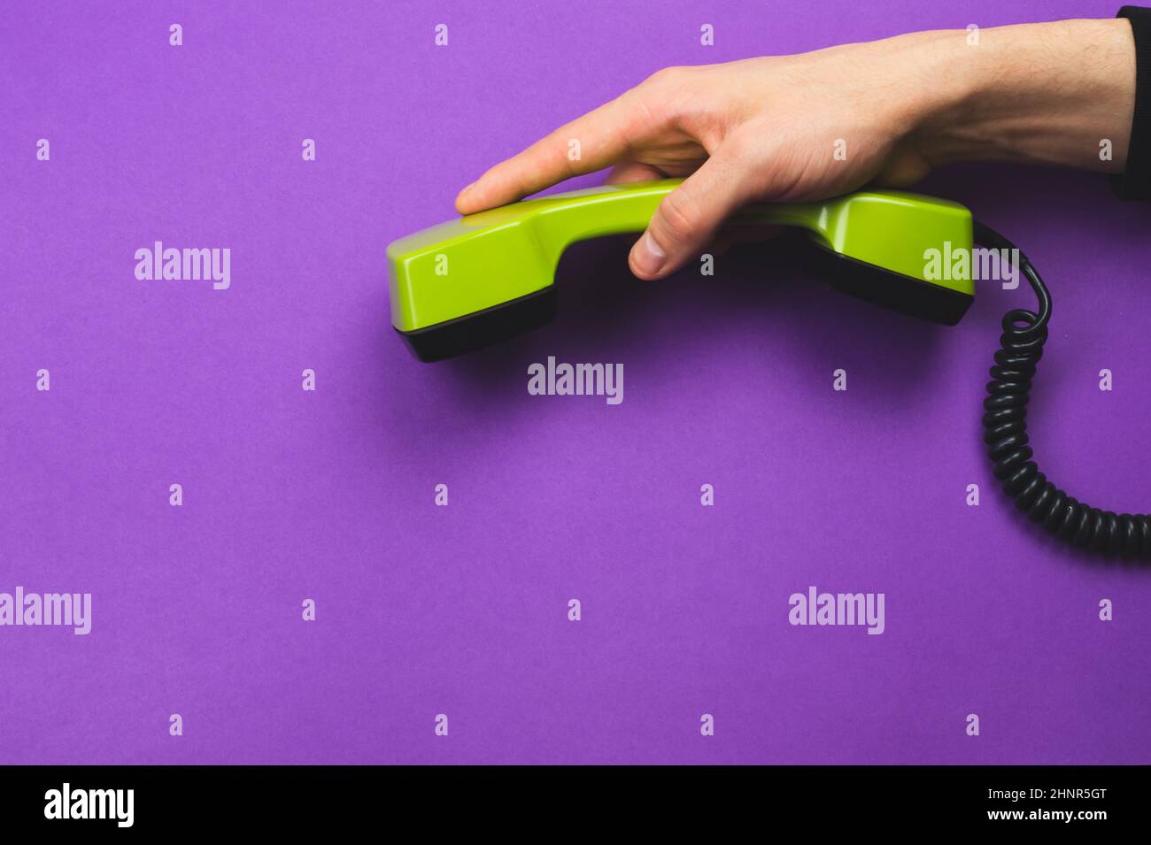 Hand holds classic telephone receiver. vintage green telephone handset ...