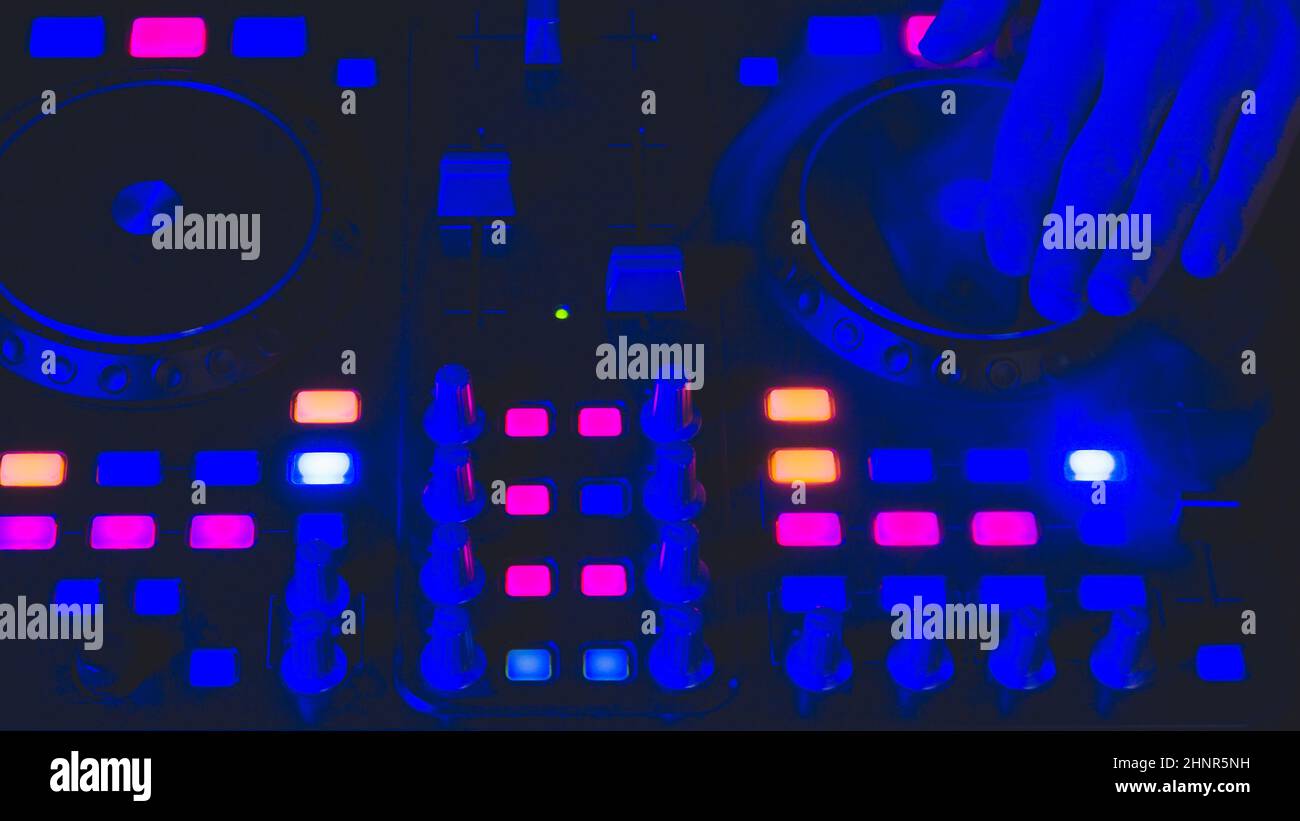 DJ plays music. sound mixer controller with knobs and sliders close up ...