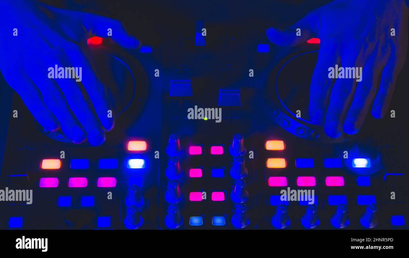 DJ plays music. sound mixer controller with knobs and sliders close up ...
