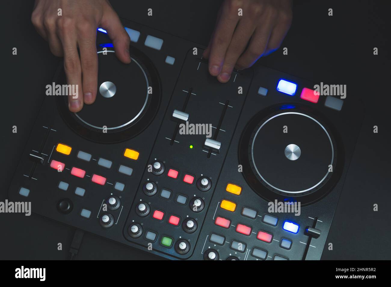 DJ plays music. sound mixer controller with knobs and sliders close up ...