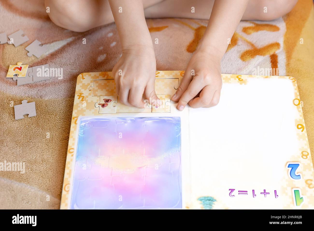 the child collects puzzles from the numbers in the book Stock Photo - Alamy