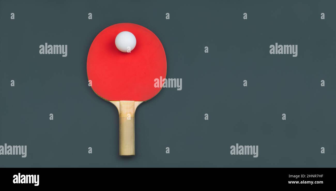 Red table tennis racket with a ball isolated on a colored background ...