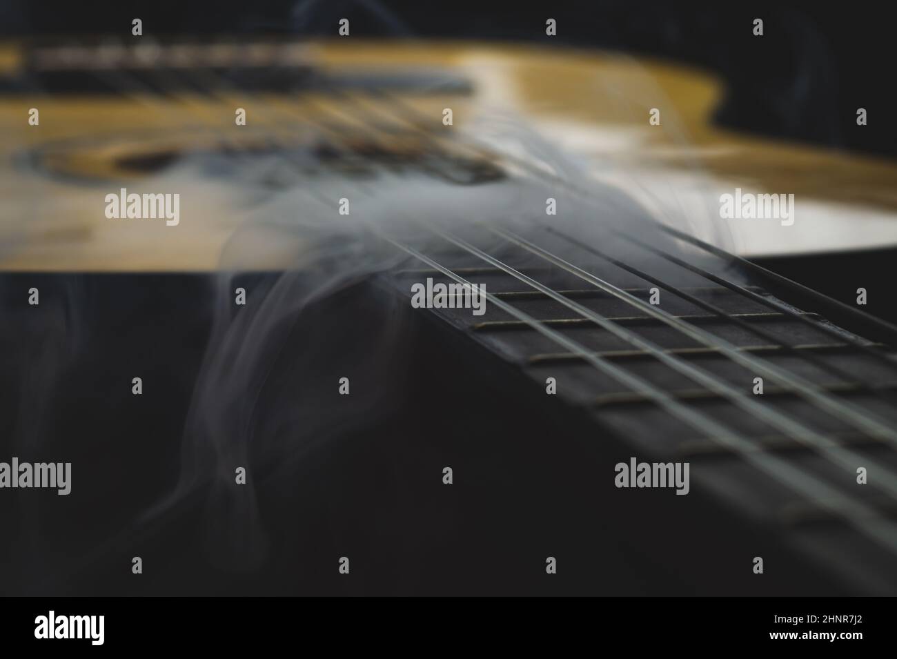 Acoustic guitar in smoke close up. musical instrument. strings on the ...