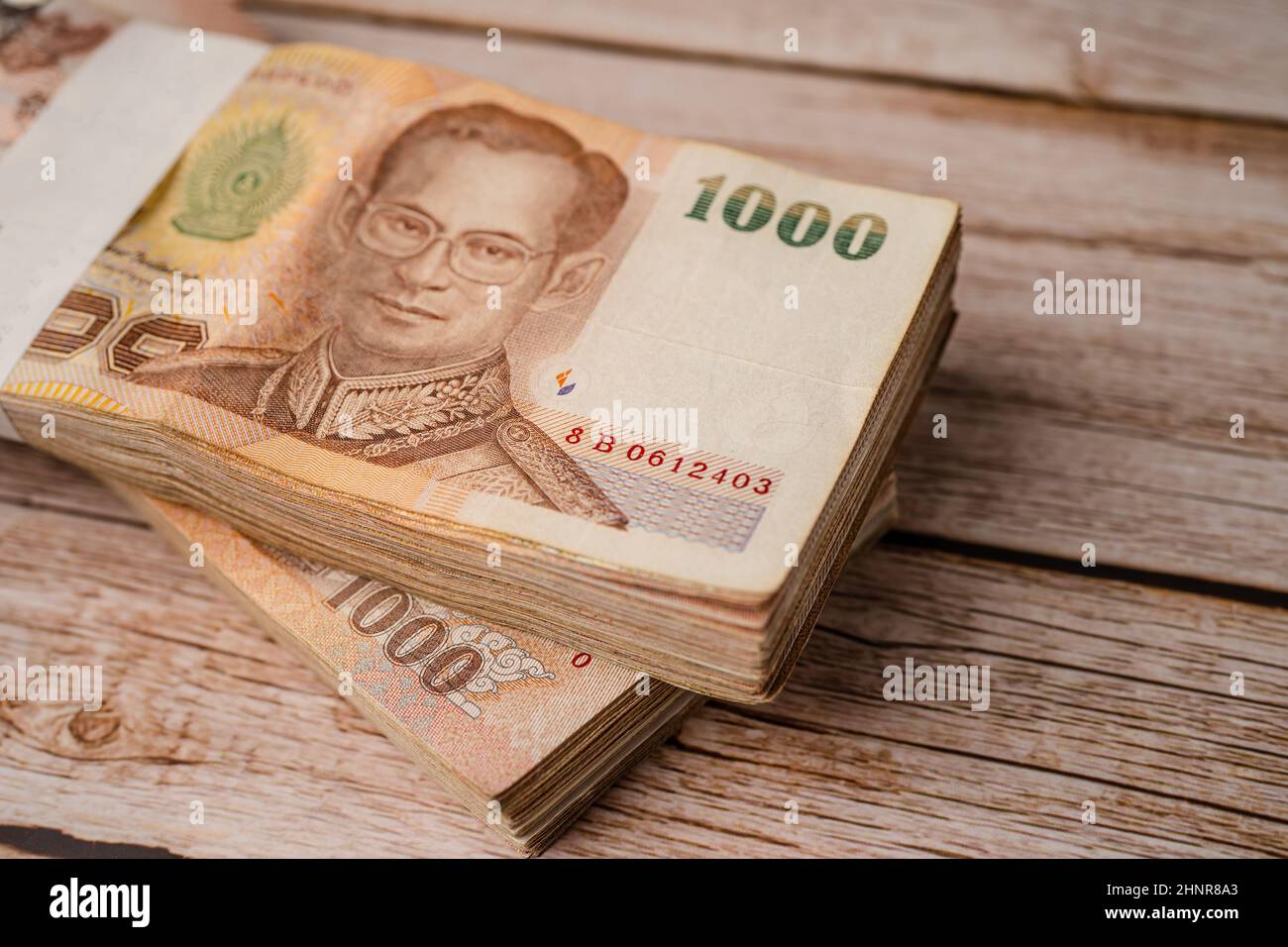 Stack of Thai baht banknotes on wooden background, business saving ...
