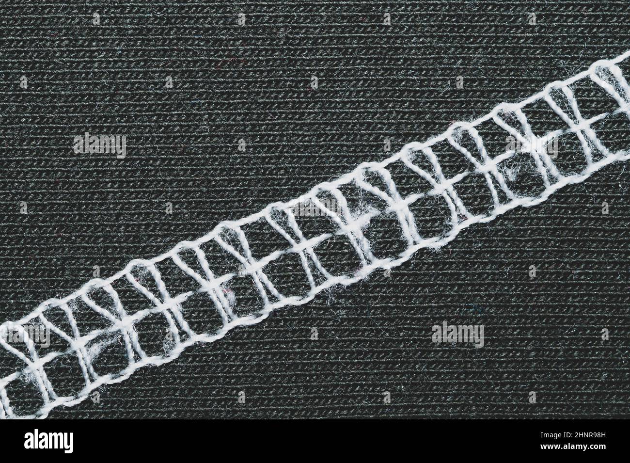 White seams on black fabric. stitches on textile material close up ...