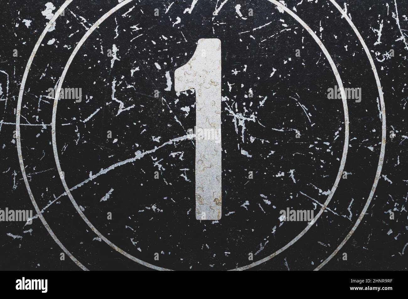 Number one painted on a metal surface. black iron plate with digit 1 ...