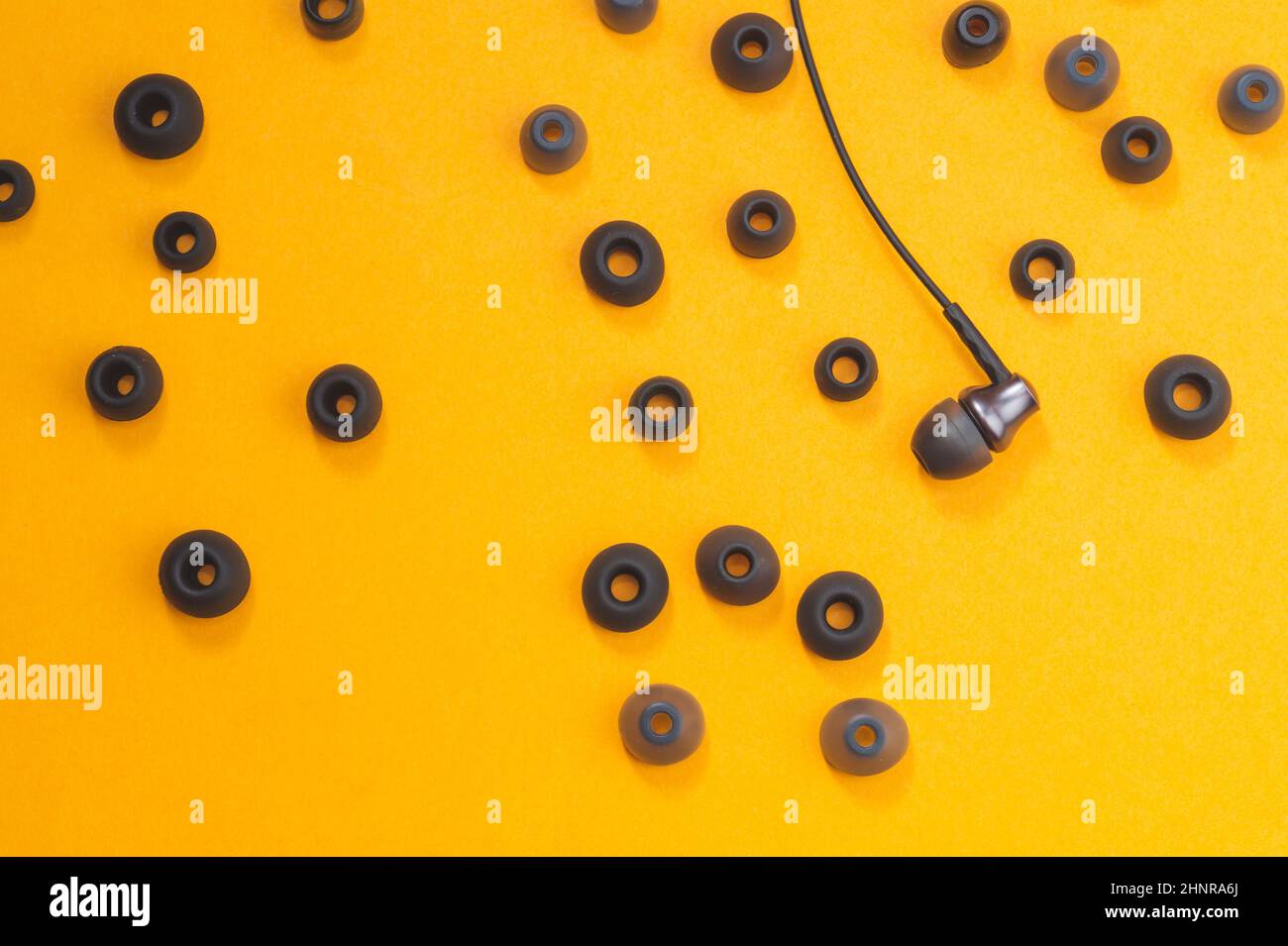 Earphones between of ear cushions on yellow background. in-ear ...