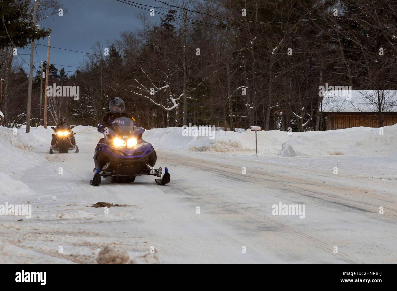 Au Train, Michigan - Snowmobile riders on a snow-covered road in ...