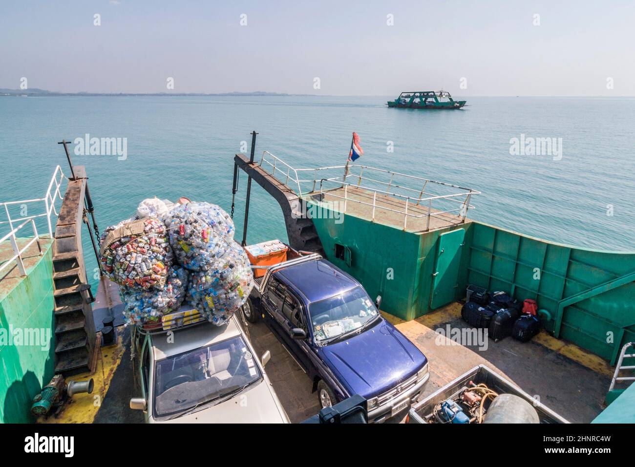 ferry with loading platform and cars, cars are loaded with cans of iron ...