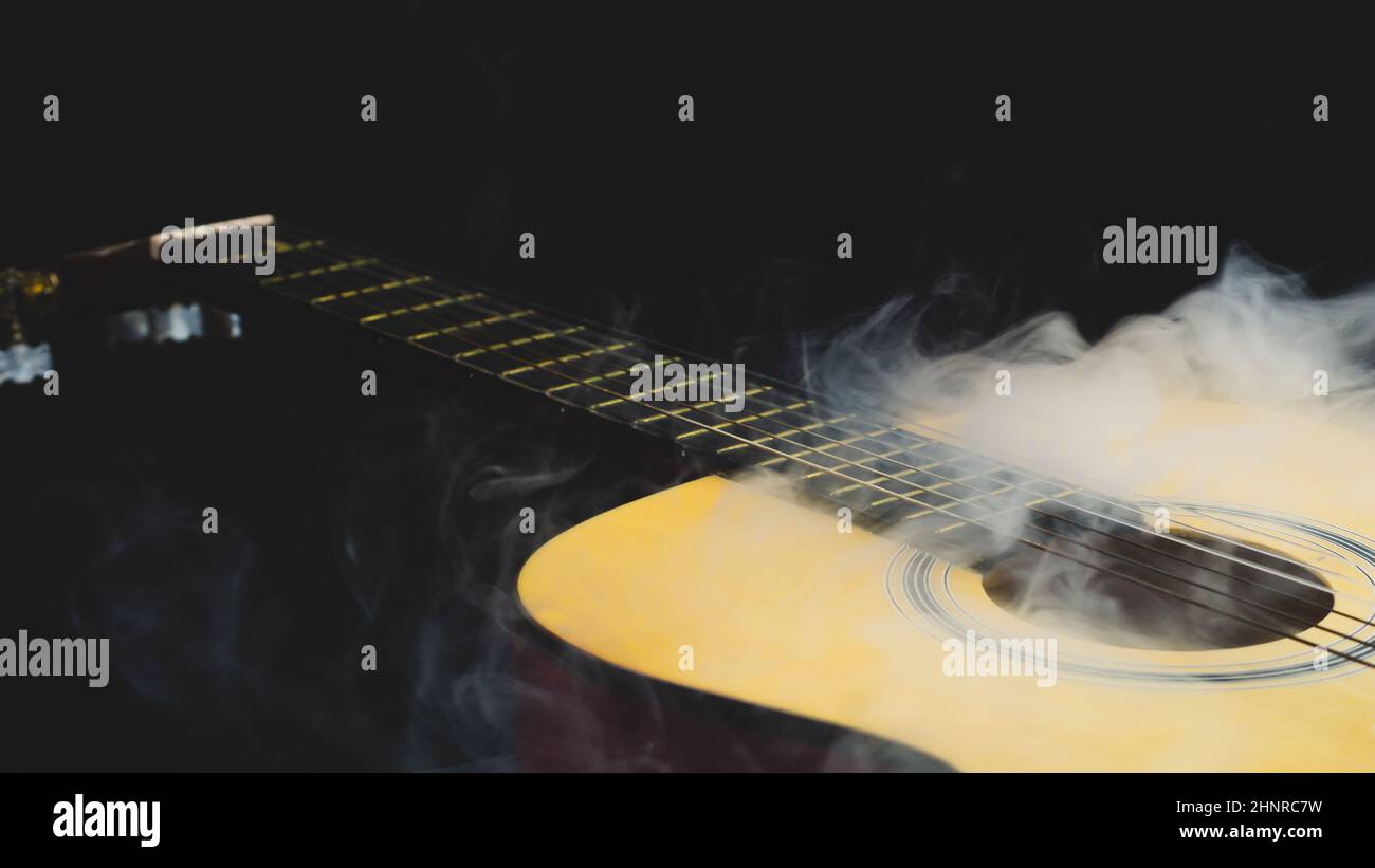 Guitar in smoke close up. acoustic musical instrument. strings on the ...