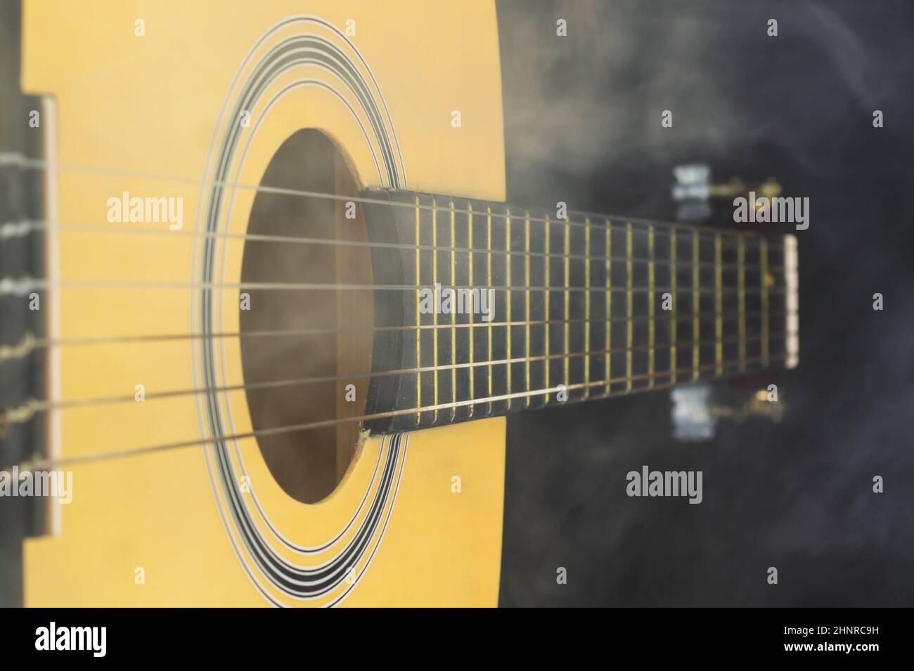 Guitar in smoke close up. acoustic musical instrument. strings on the ...