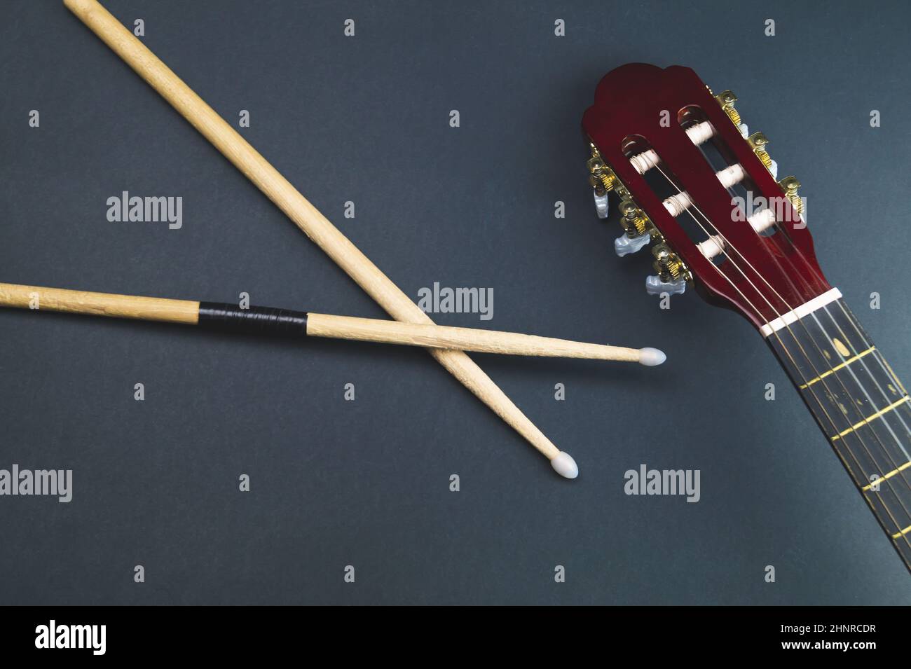 Drumsticks and guitar headstock close up. acoustic musical instrument ...