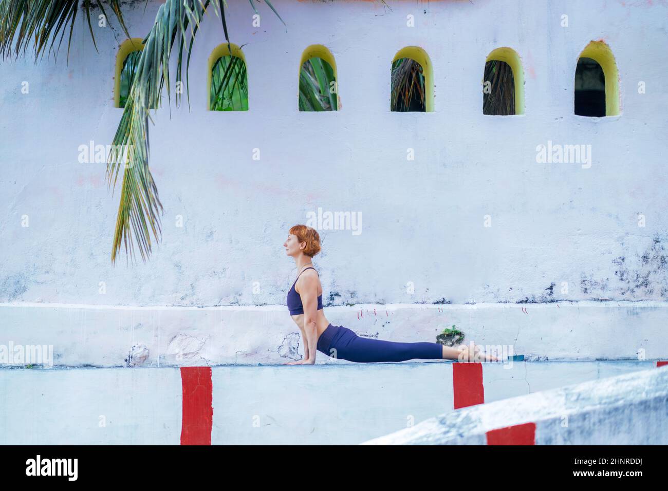 Yogini in a blue outfit training near the white Hindu temple Stock ...