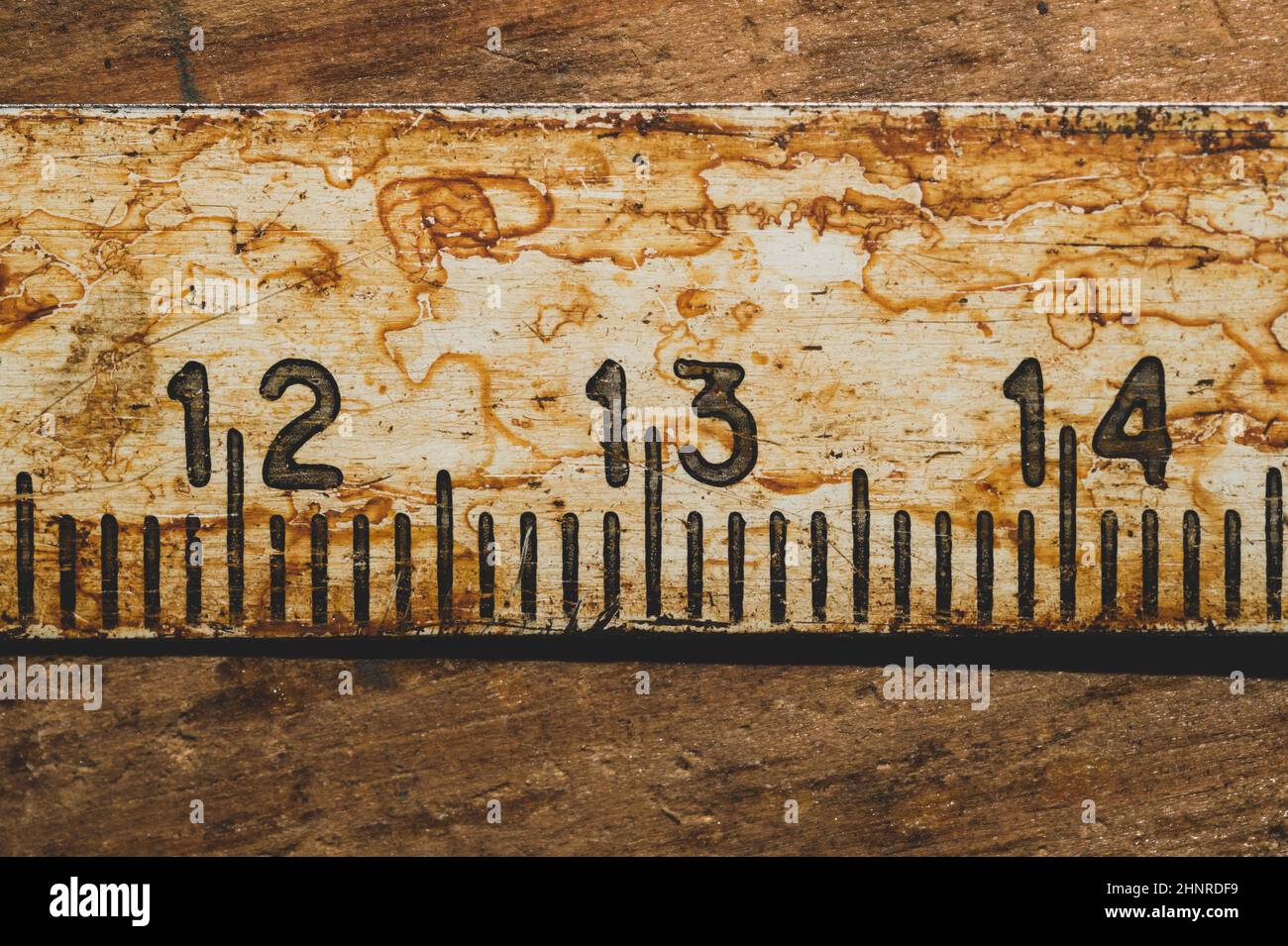 Old rusty ruler with black numbers on a working wooden table. vintage ...