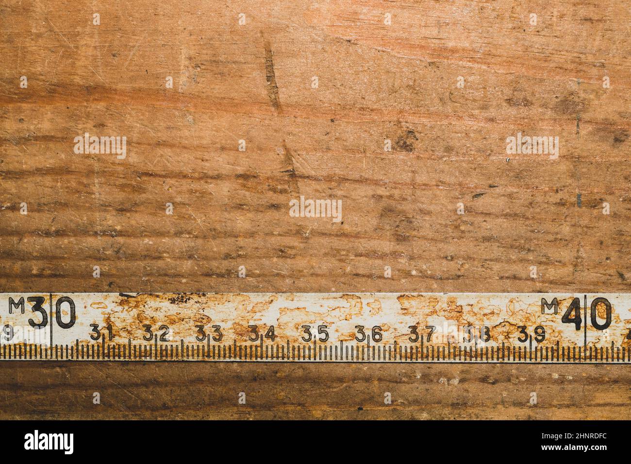 Old rusty ruler with black numbers on a working wooden table. vintage ...