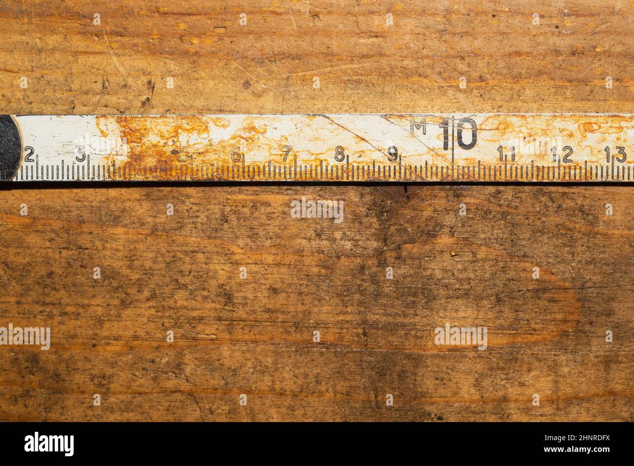 Old rusty ruler with black numbers on a working wooden table. vintage ...
