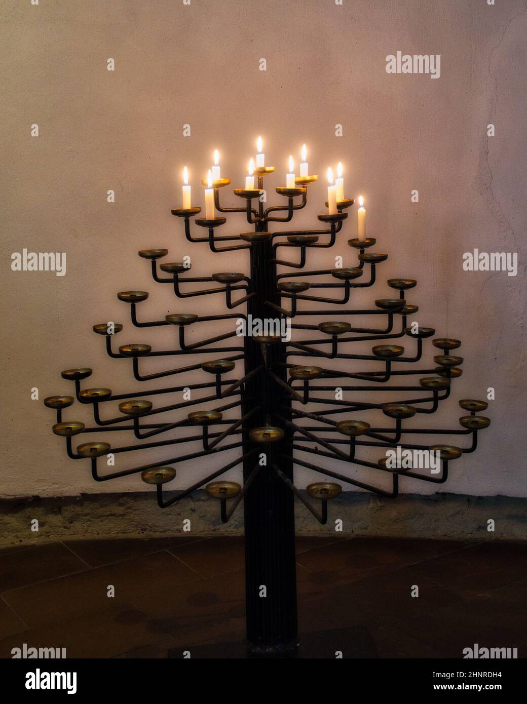 A metal candlestick in the shape of a fir tree with burning candles in ...