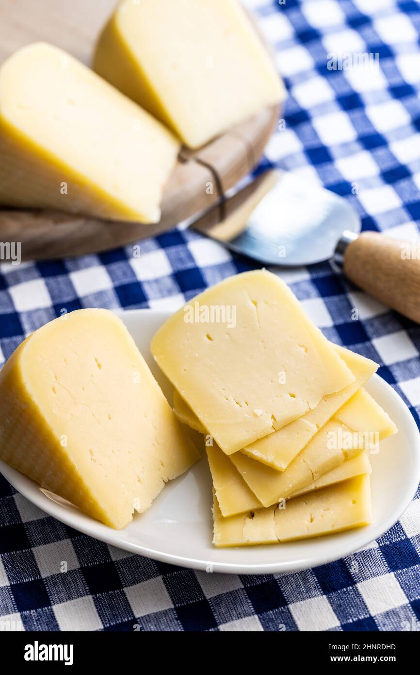 Block of hard cheese. Sliced cheese on plate Stock Photo - Alamy