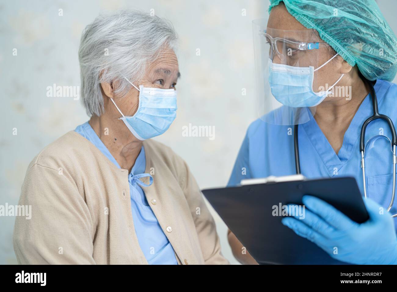 Asian doctor wearing face shield and PPE suit new normal to check ...