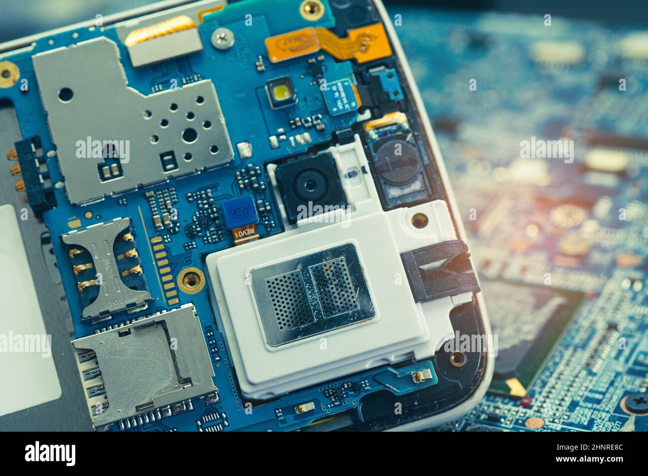 Technician repairing inside of mobile phone by soldering iron ...
