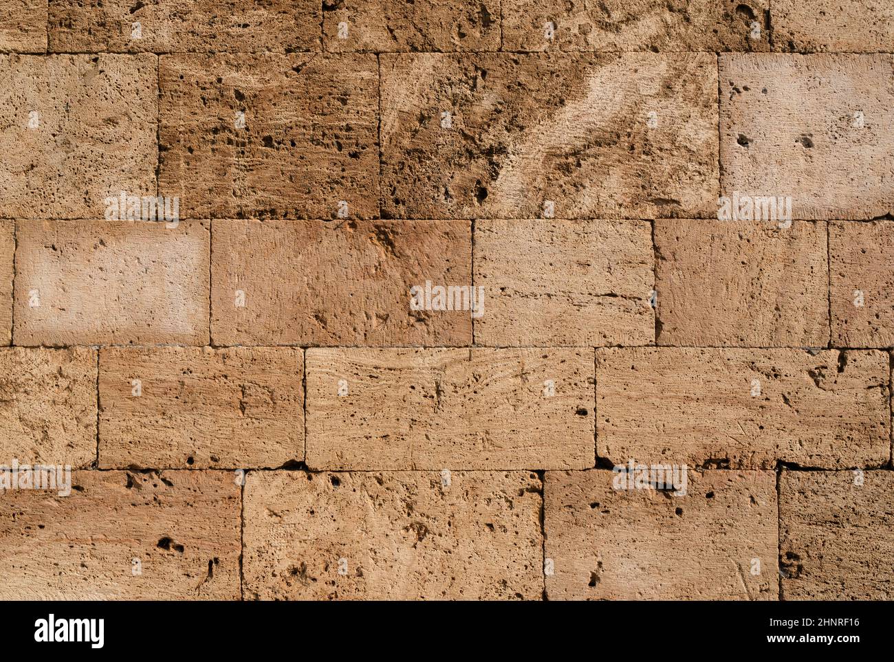 horizontal front view of ancient brown stone wall made of brown ...