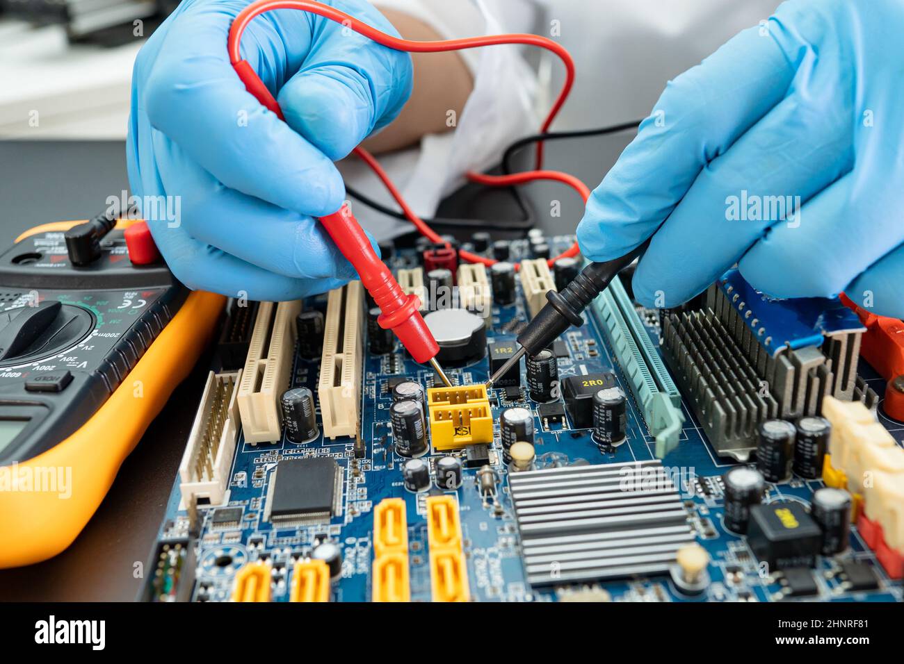 E-waste, technician repairing inside of hard disk by soldering iron ...